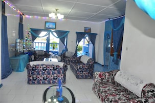 Sala de estar com sofás estampados, uma mesa de centro de vidro e um pinheiro de Natal.