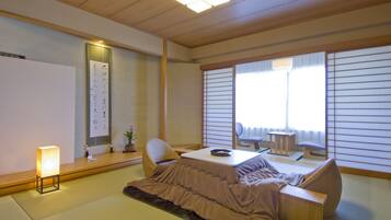 Um quarto japonês tradicional com tatames, uma mesa baixa e um espaço de estar acolchoado.