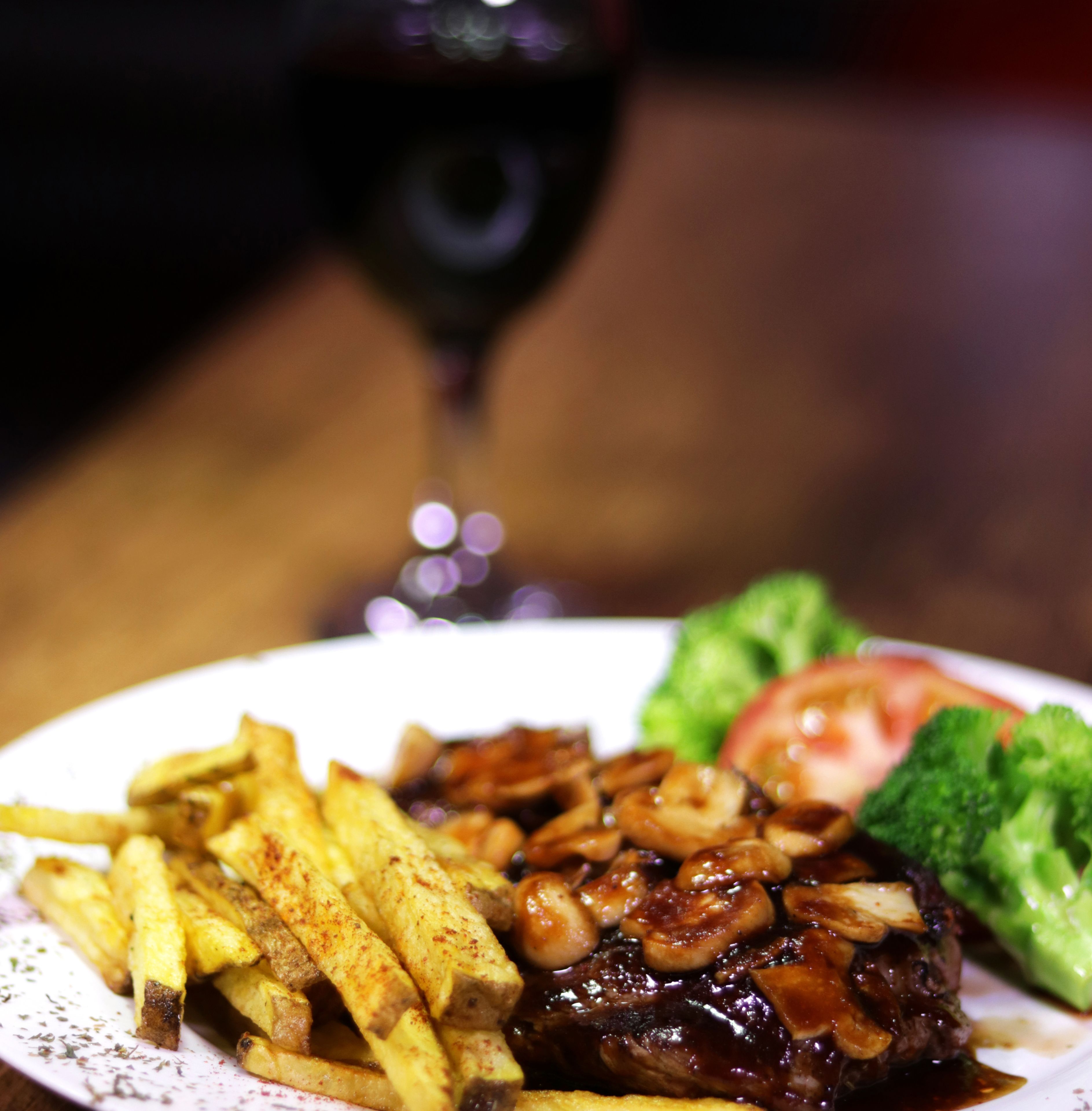 Um prato de comida com batatas fritas, carne e legumes.