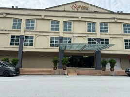 Um hotel com entrada coberta, várias janelas e uma placa com o dizer 'De' Nangka Mart' sobre a entrada.