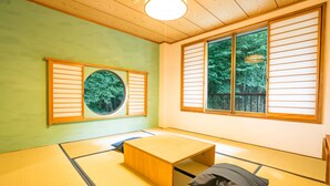 Um quarto japonês tradicional com tatames, uma mesa de madeira baixa e biombos shoji.