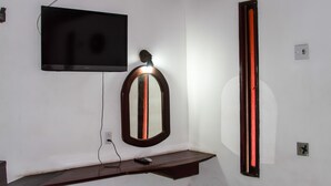 Quarto com televisão de tela plana fixada na parede, espelho com moldura de madeira e faixa de luz vermelha na parede.