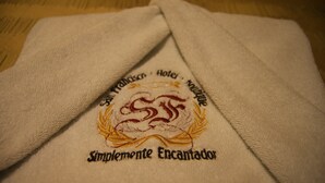 Uma toalha com bordado de texto e um logotipo, provavelmente de um hotel.