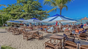 Na praia, praia de areia branca, espreguiçadeiras, guarda-sóis de praia