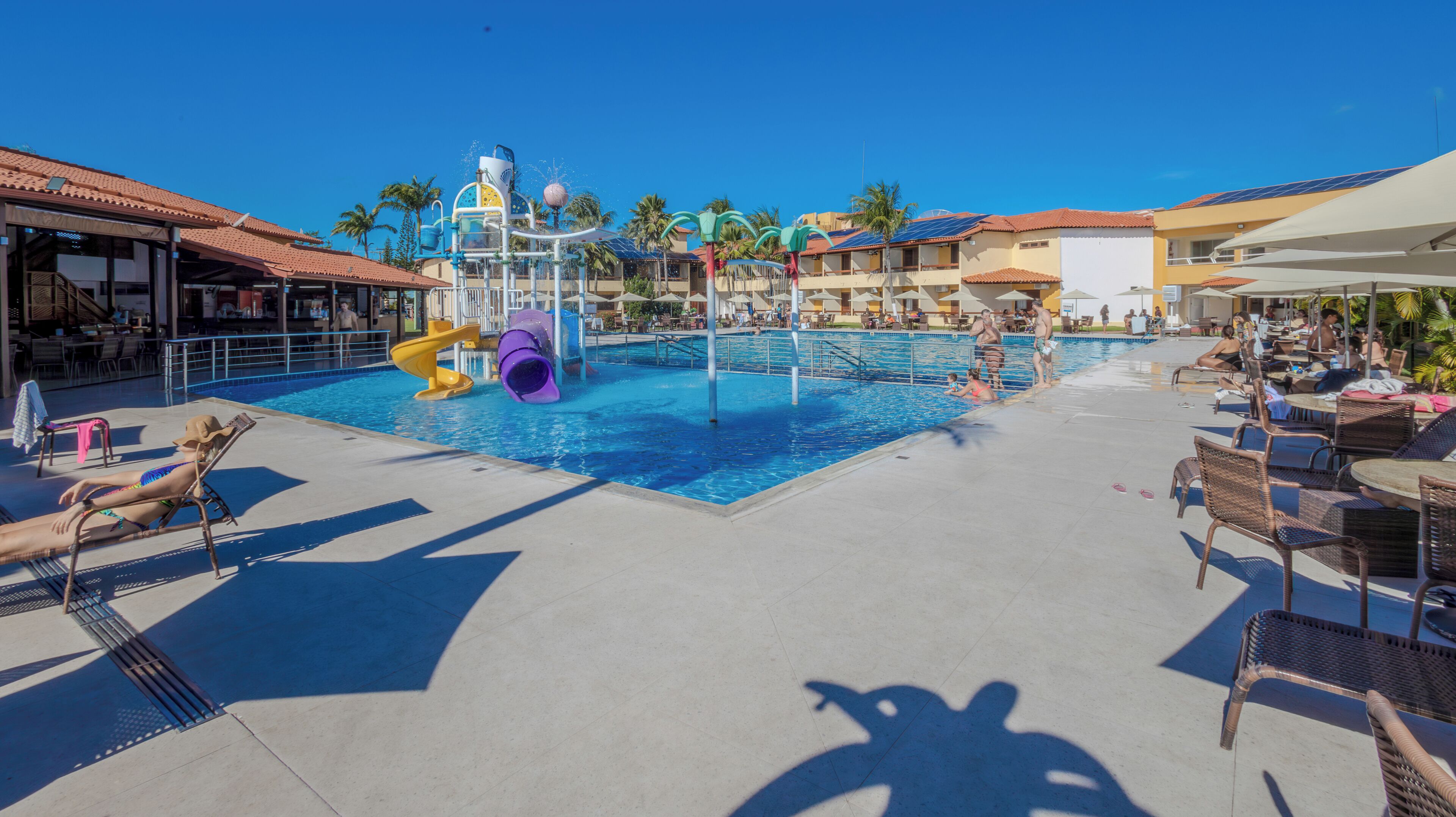 Uma área de piscina com toboáguas e cadeiras de descanso.