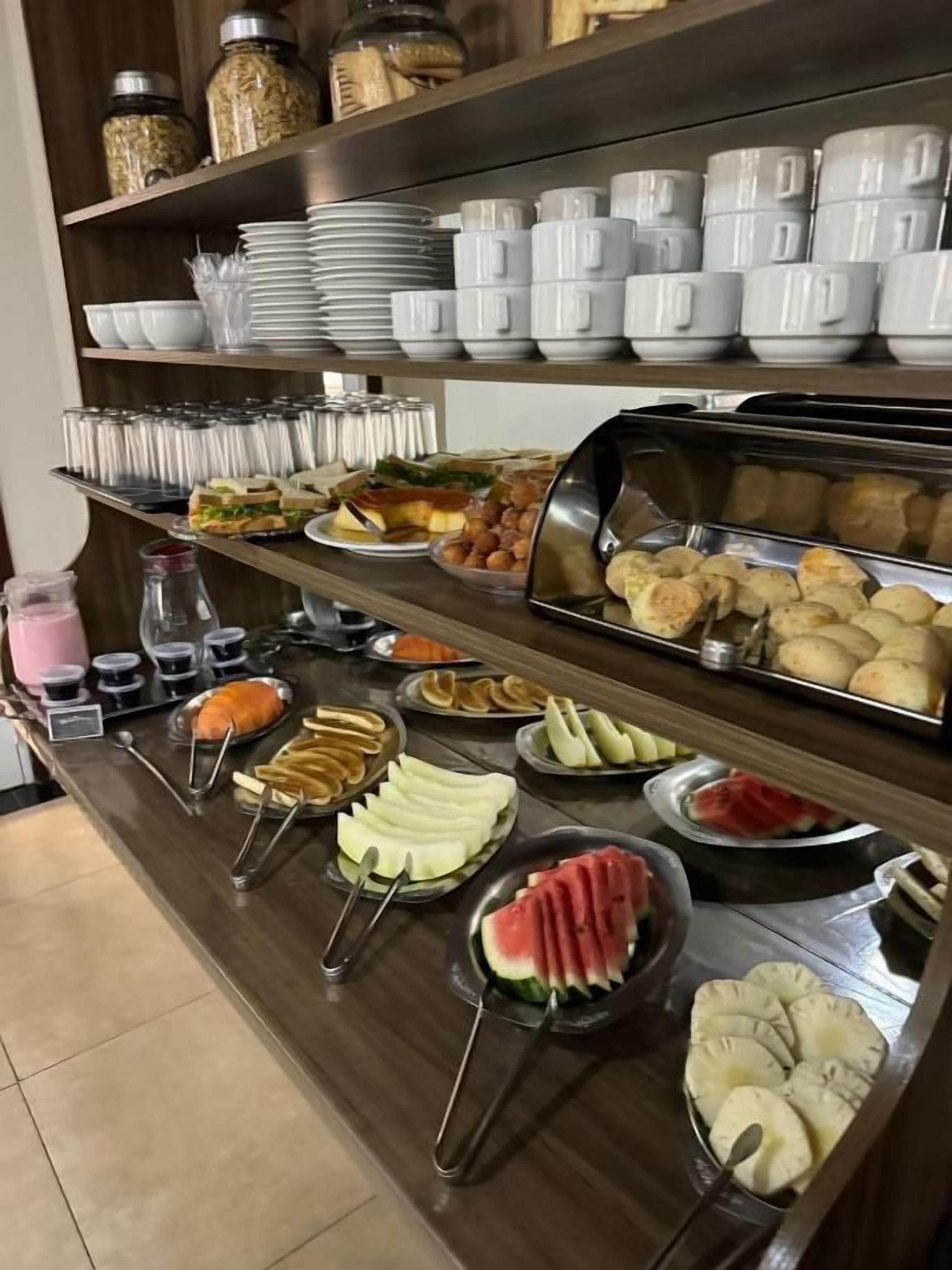 Disposição de buffet com diversos alimentos e utensílios.