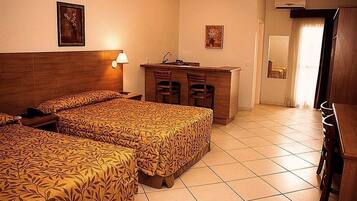 Quarto de hotel com duas camas, uma escrivaninha e uma cadeira.