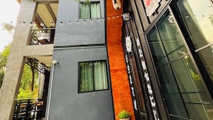 Um edifício moderno com fachada cinzenta, detalhes em madeira e uma placa com caracteres japoneses.