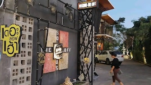 Um edifício com a placa 'Welcome to the Loft', entrada fechada por portão e um carro estacionado na entrada.