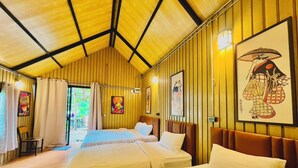 Quarto com duas camas, painéis de madeira e obras de arte nas paredes.
