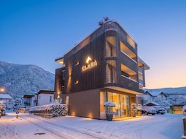 Um hotel de vários andares com design moderno, exibindo uma placa grande com a inscrição 'CLARA' na fachada.