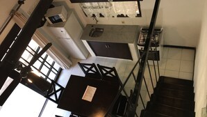 Cozinha com fogão, pia e área de jantar com cadeiras e mesa.