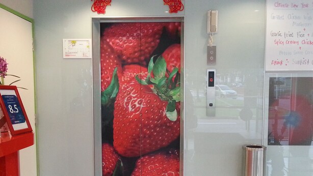 Um elevador com uma parede decorada com tema de morango.
