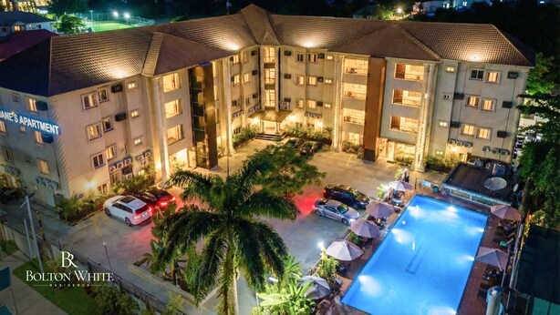 Um hotel de vários andares com piscina e área de estar ao ar livre.