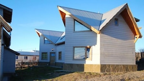 Uma casa moderna com telhado inclinado e uma janela grande.