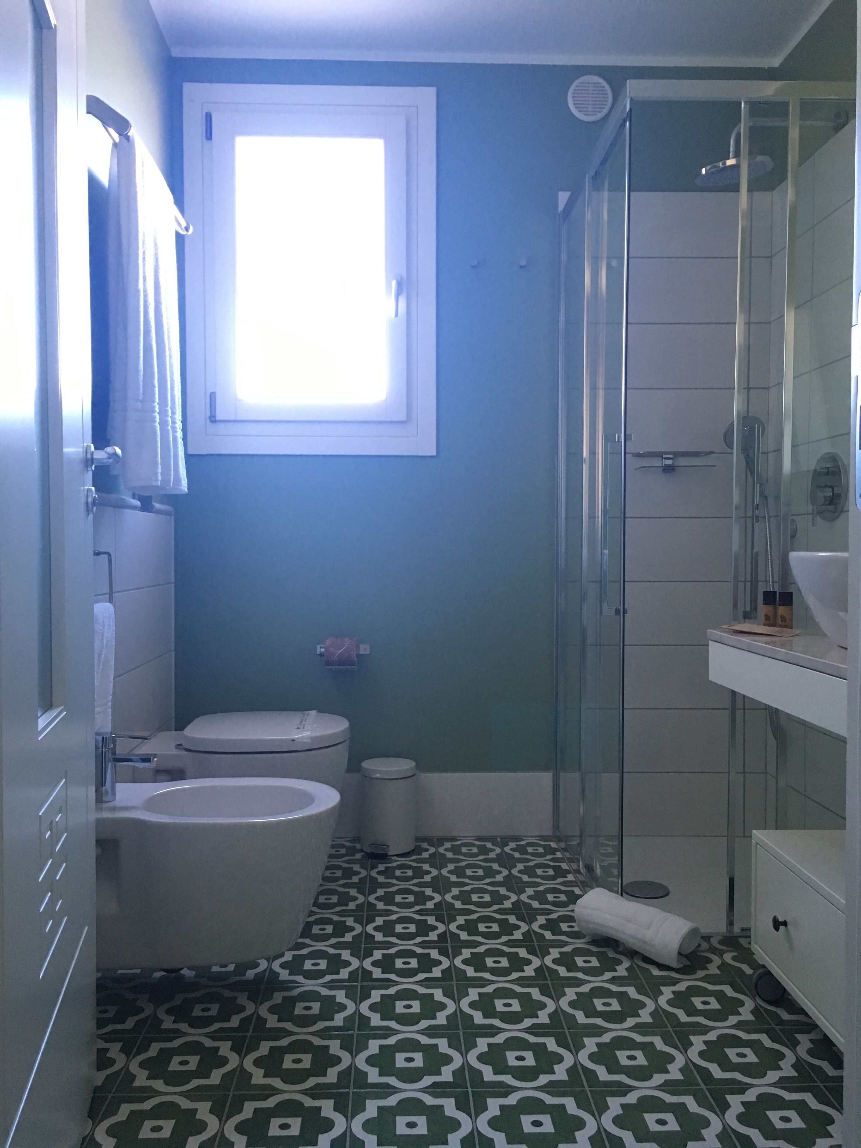 Casa de banho com sanita, bidé e cabine de duche.
