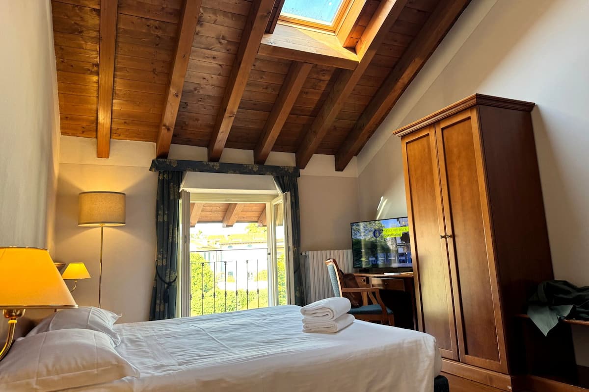 Quarto com cama, escrivaninha, televisão e guarda-roupa.