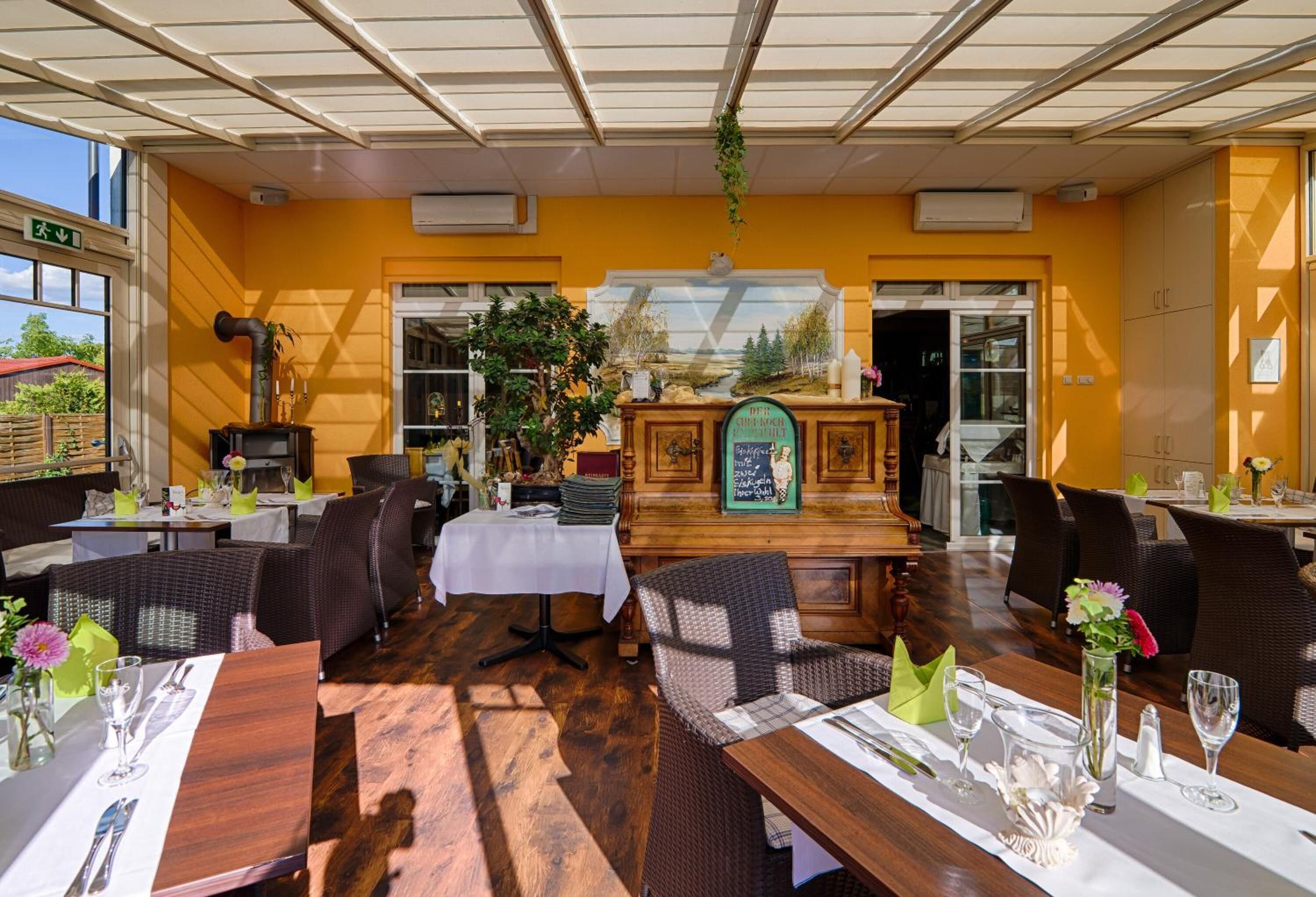 Uma área de refeições ao ar livre com mesas e cadeiras de madeira, uma mesa de buffet central e vista para a paisagem circundante.