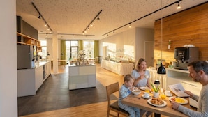 Uma cozinha moderna com área de jantar, armários de madeira e uma ilha central.