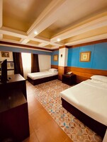 Quarto de hotel com duas camas, uma mesa, telefone e televisão.