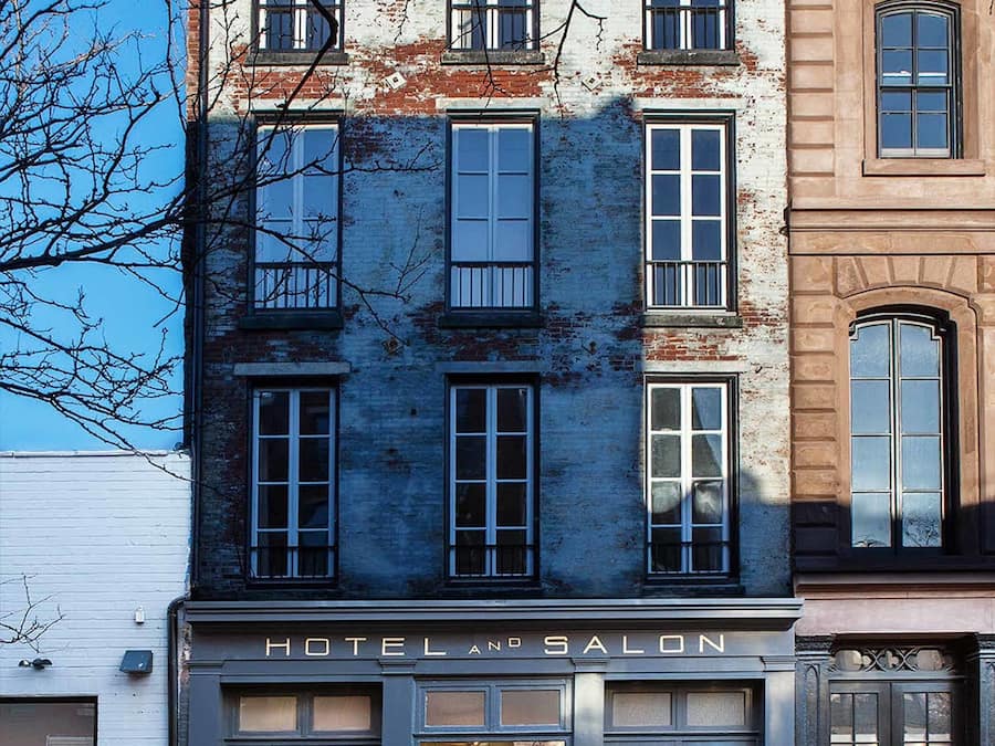 Um edifício de dois andares com uma placa que diz 'HOTEL AND SALON'.