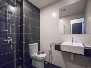 Casa de banho moderna com parede revestida a preto, sanita branca, lavatório e chuveiro.