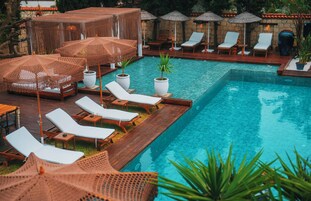 Uma área de piscina com espreguiçadeiras e guarda-sóis.