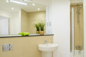 Banheira, secador de cabelo, toalhas de banho 