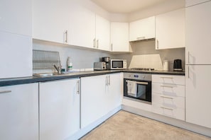 Apartamento, 3 quartos | Cozinha privada | Um frigorífico, um micro-ondas, uma placa de cozinha 