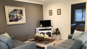 Suite-Estúdio Design, 1 quarto, kitchenette, junto ao jardim | Sala de estar | TV de ecrã plano, leitor de DVD 