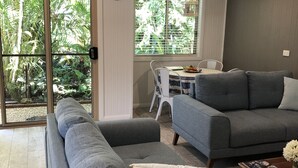 Suite-Estúdio Design, 1 quarto, kitchenette, junto ao jardim | Sala de estar | TV de ecrã plano, leitor de DVD 