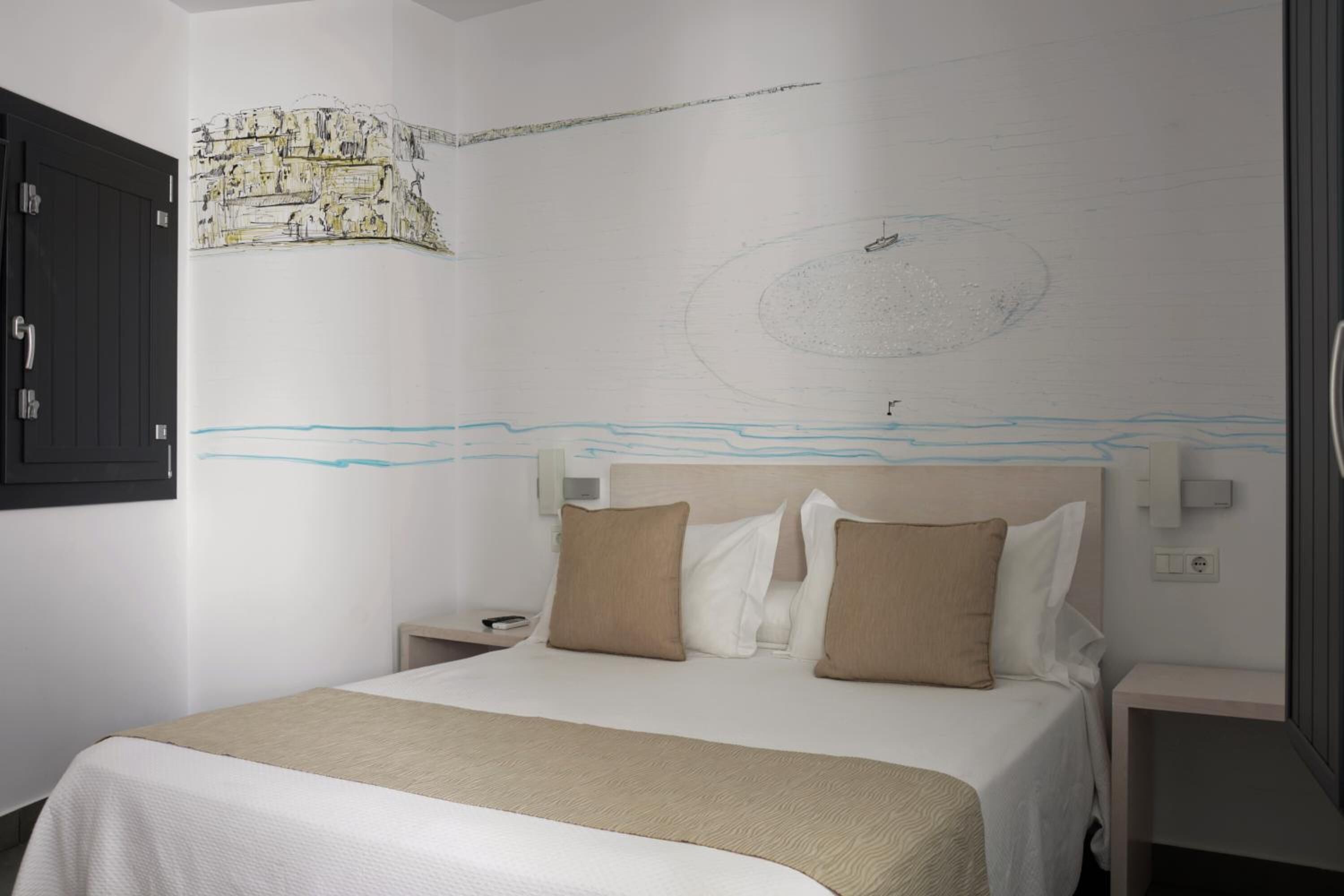 Quarto com cama, duas mesas de cabeceira, parede com mural e uma porta.