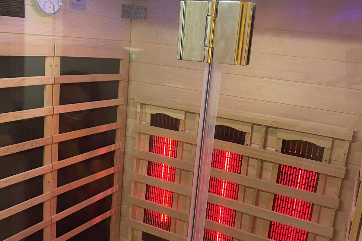 Um quarto com uma divisória de madeira, um relógio na parede e um teto com luzes LED azuis.
