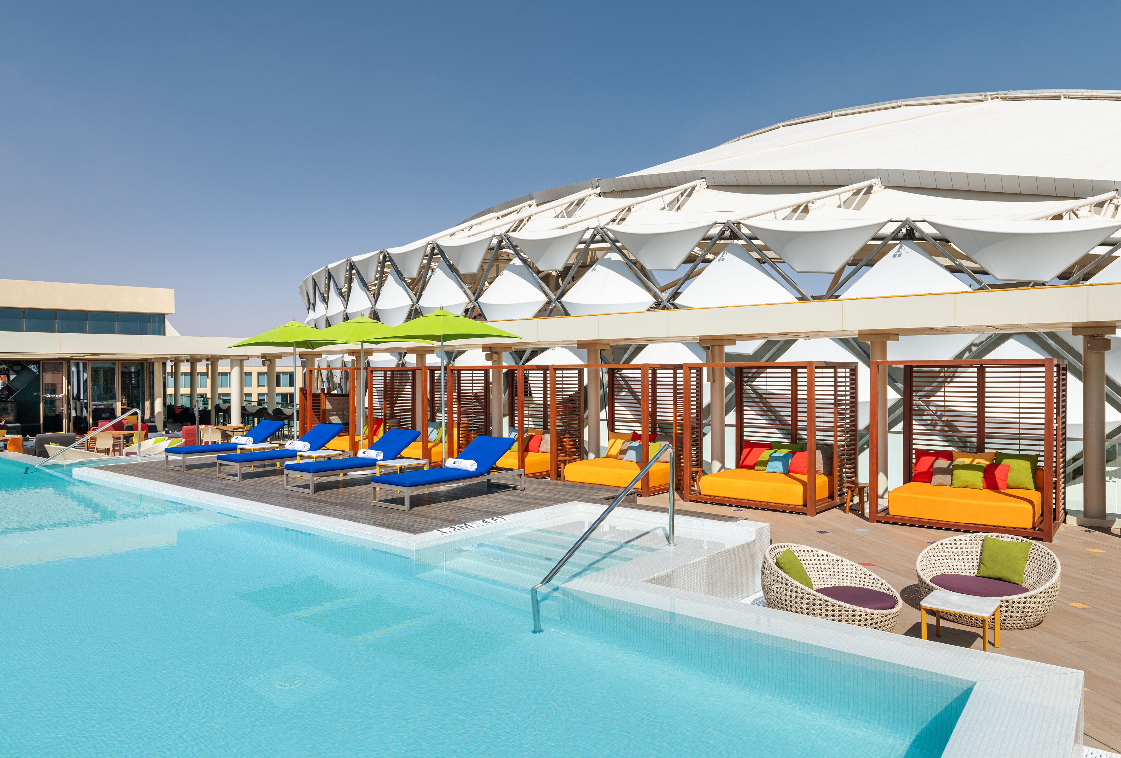 Uma área de piscina com espreguiçadeiras e um espaço coberto para sentar.