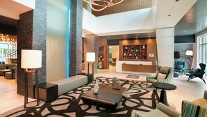 Um lobby moderno com recepção, área de estar e um grande lustre.