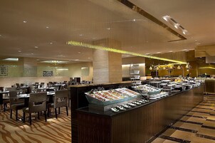 Uma área de buffet com várias estações de comida e opções de assentos.