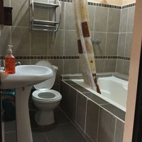 Um banheiro com vaso sanitário, pia e banheira.