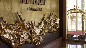 Paredes com o texto "ALFABRIGA" e um detalhe dourado decorativo.