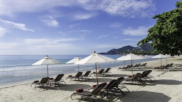 Na praia, guarda-sóis de praia, toalhas de praia, massagens na praia