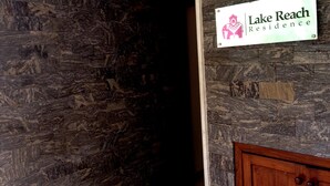 Placa para Lake Reach Residence, com logotipo de uma casa e uma pessoa.