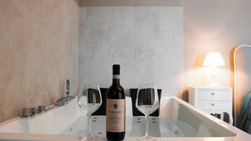 Uma banheira com duas taças de vinho e uma garrafa.