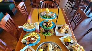 Uma mesa de jantar com diversos pratos, incluindo frutos do mar, saladas e pão.
