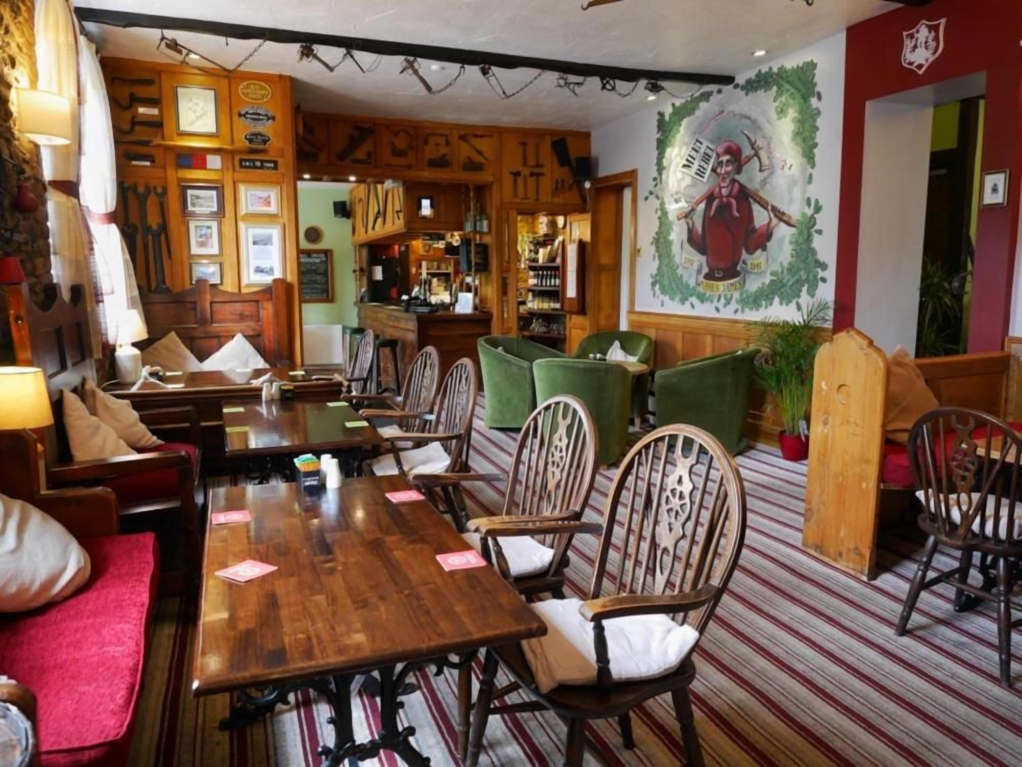 Um restaurante com mobiliário de madeira, um espaço de bar e um mural na parede.