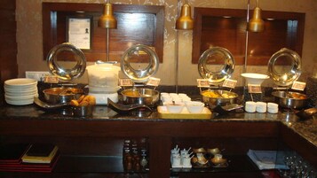 Buffet com diversos pratos e acompanhamentos.
