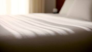 Um close-up de uma cama com cobertura branca texturizada.