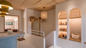 Cozinha moderna com ilha central, luminária pendente e armários embutidos com utensílios de cozinha.