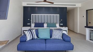 Quarto moderno com uma cama grande, um sofá azul e um ventilador de teto.