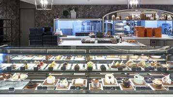 Vitrine de pastelaria com diversos bolos e doces.