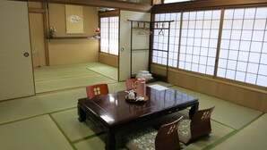 Um quarto japonês tradicional com tatames, uma mesa de madeira e um painel shoji.