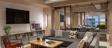 Uma sala de estar moderna com sofá, mesa de centro e televisão fixada na parede.